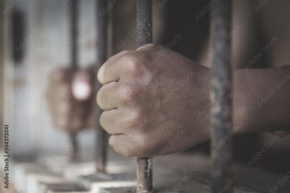 Man in prison hands of behind hold Steel cage jail bars, Male prisoners ...