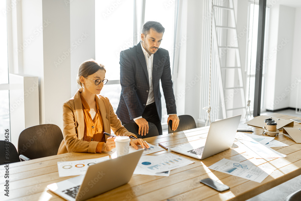 Two office employees dressed casually in the suits having some office ...