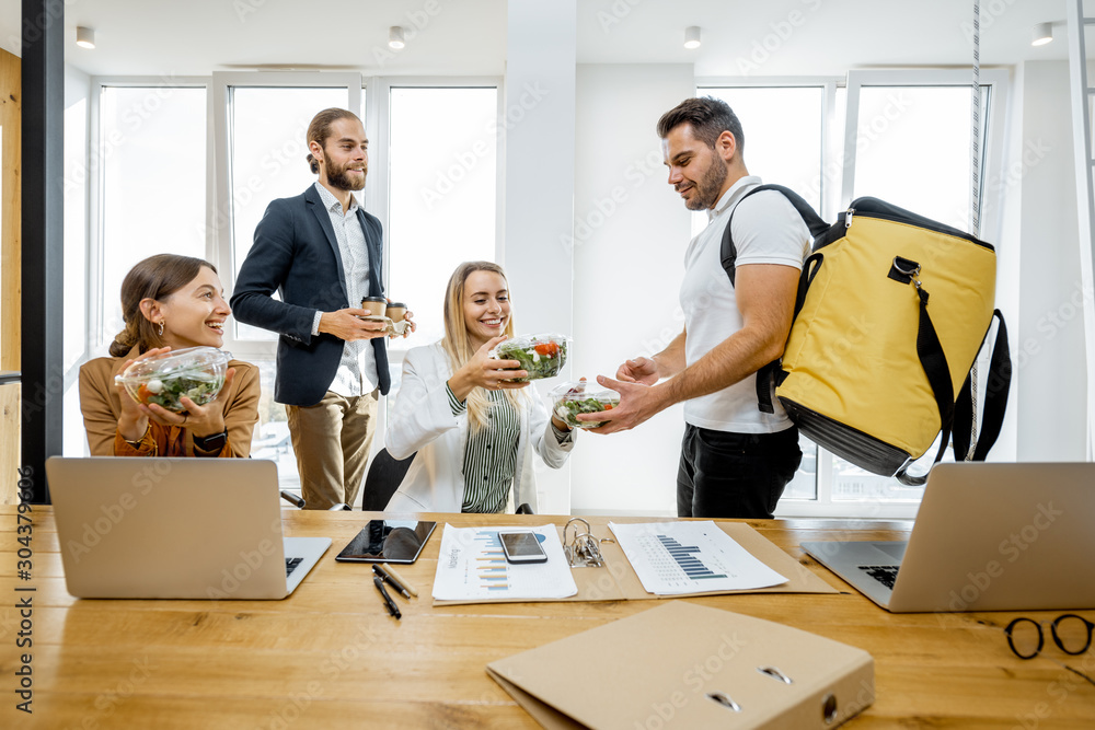 Courier delivering healthy business lunches with thermal bag for the ...