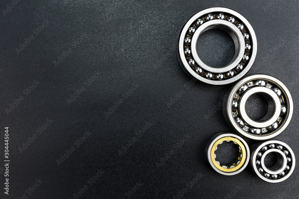 Ball bearing lying on a black background with copy space on the left ...