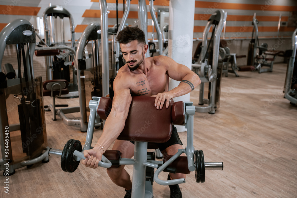 Details bodybuilding man doing exercises in a large spacious gym ...