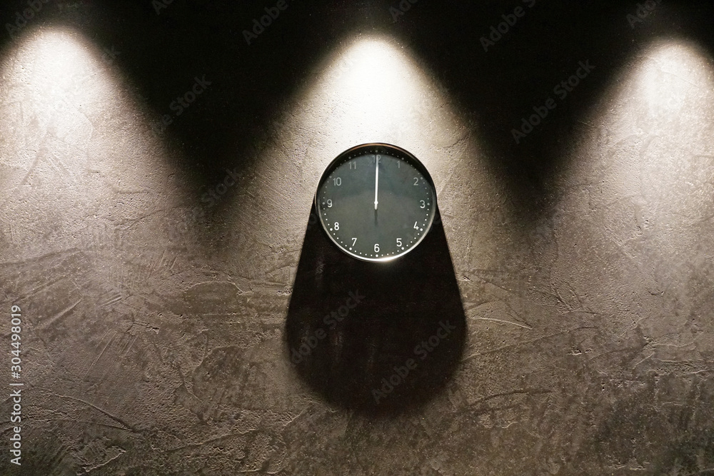 Black simple analog clock showing midnight hanging on the wall with ...