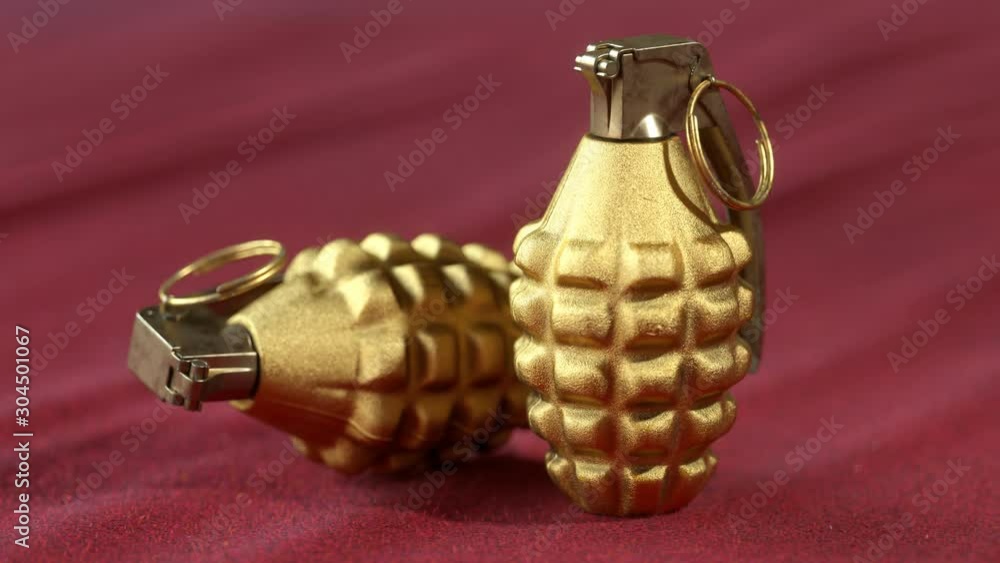 MK2 hand grenades. Two golden pineapple grenades on the red velvet ...