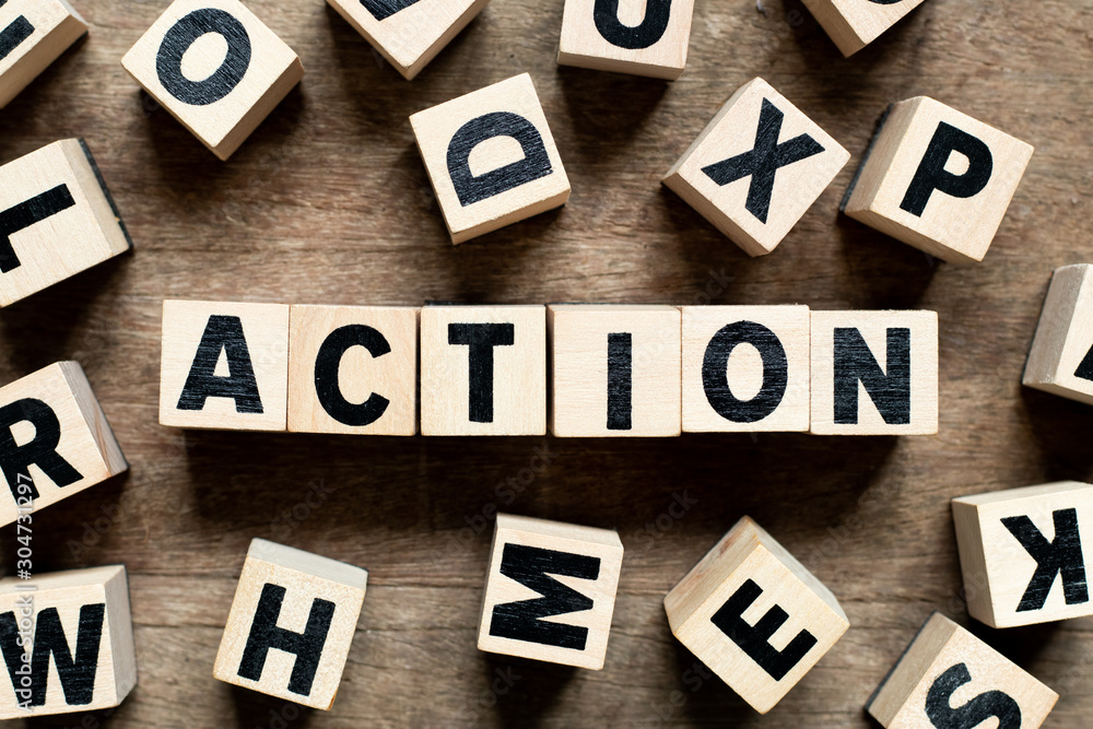 Letter block with word action on wood background with another alphabet ...