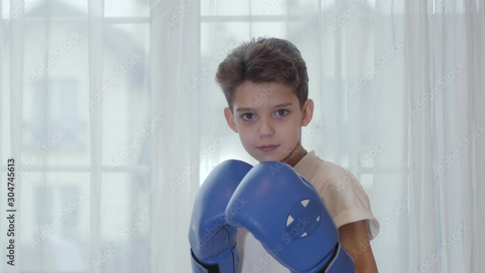 Portrait of young Caucasian boy boxing at camera. Cute schoolboy in ...