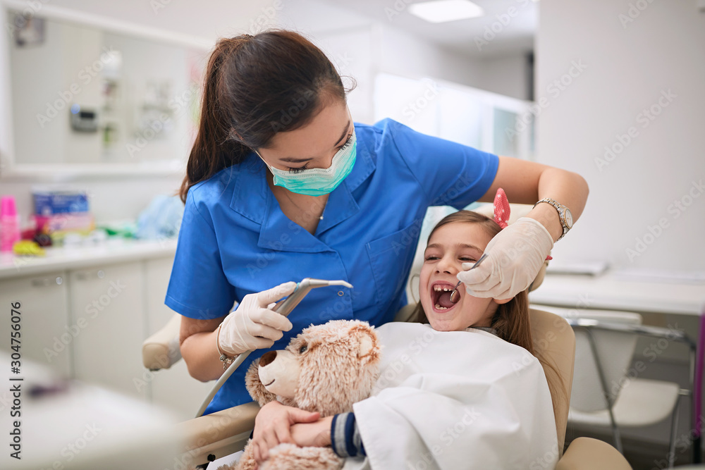 Dentist woman examining tooth patient at dental procedure. Stock Photo ...