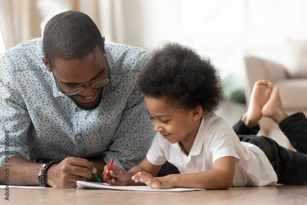 Caress father drawing with son family lying on warm floor Stock Photo ...