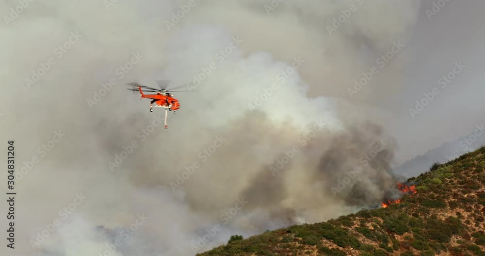 Nature protection. The firefighting helicopter drops the load of water ...