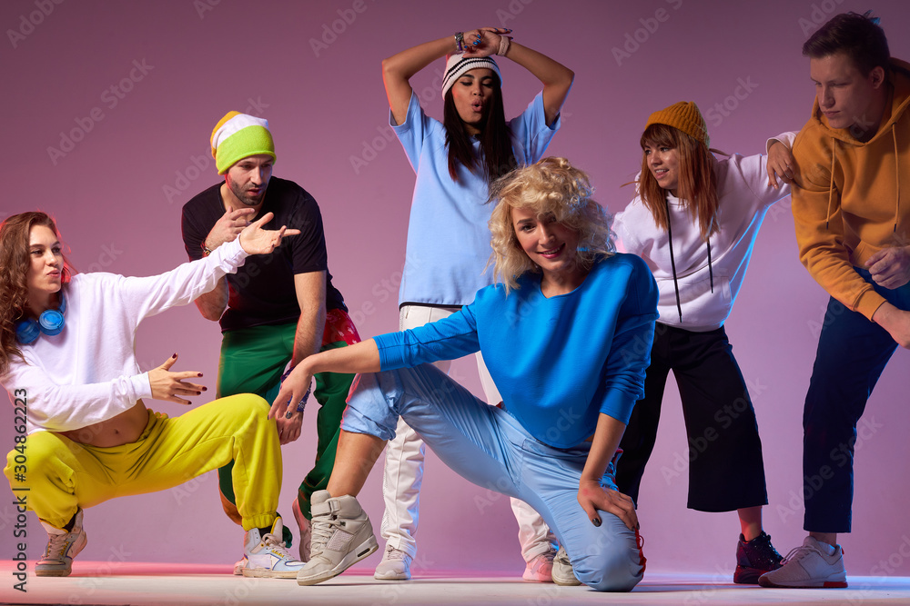 Playful cheerful group of people happily looking at female dancer ...