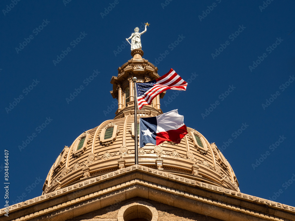 US flag and flag of Texas flying proudly above the Texas State Capital ...
