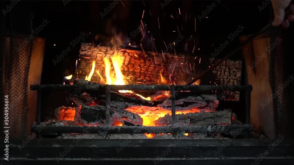 Close up of slow burning logs In a vintage brick fireplace with screen ...