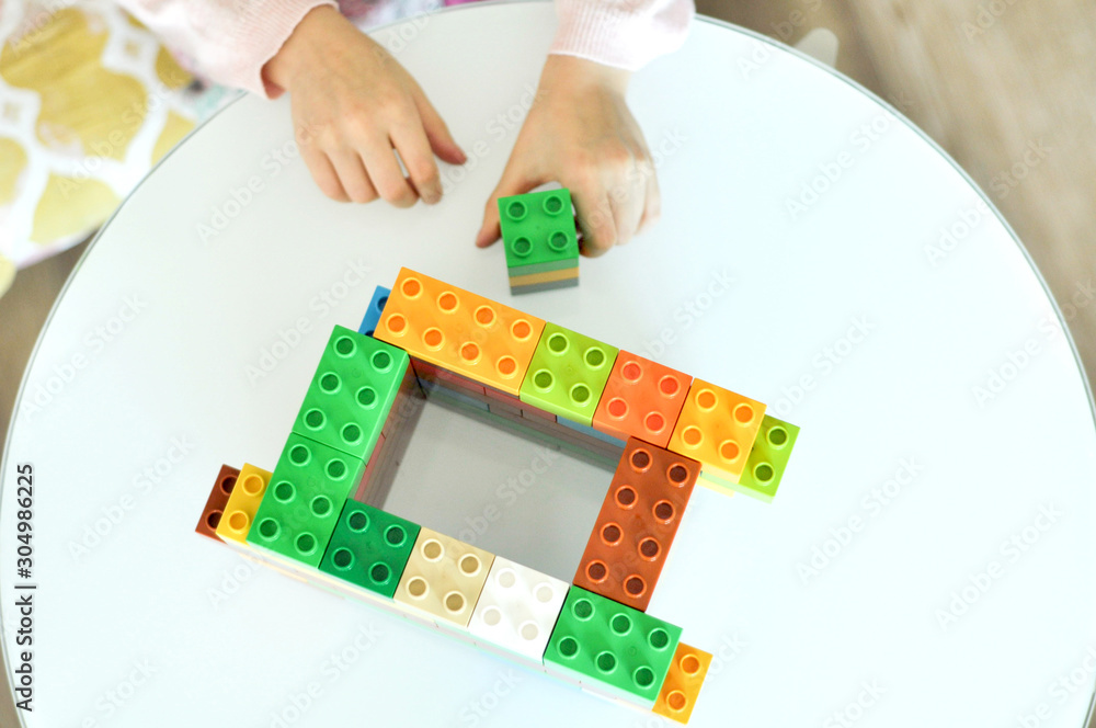 Child playing with plastic colorful blocks constructor at kindergarten ...