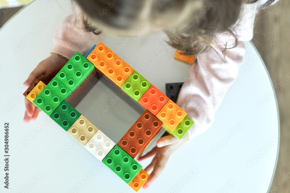 Child playing with plastic colorful blocks constructor at kindergarten ...