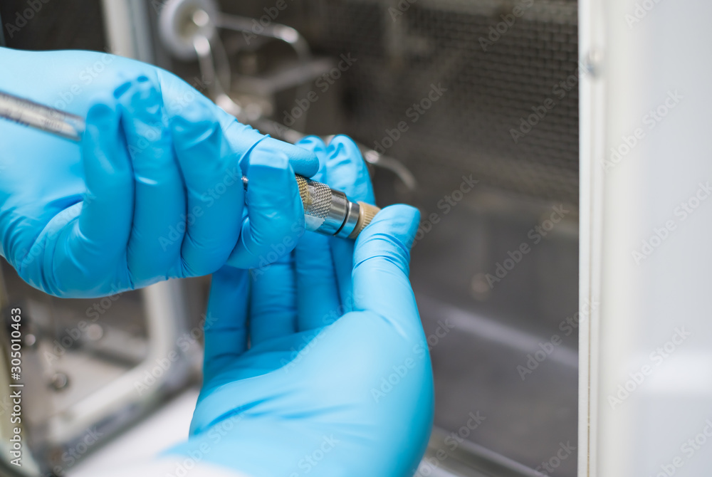 Analyst is working in laboratory with connecting HPLC column to the ...