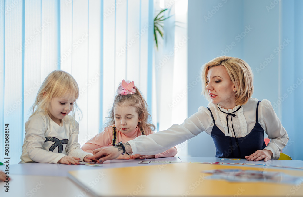 Two girls of elementary age in class with teacher. New methods of ...