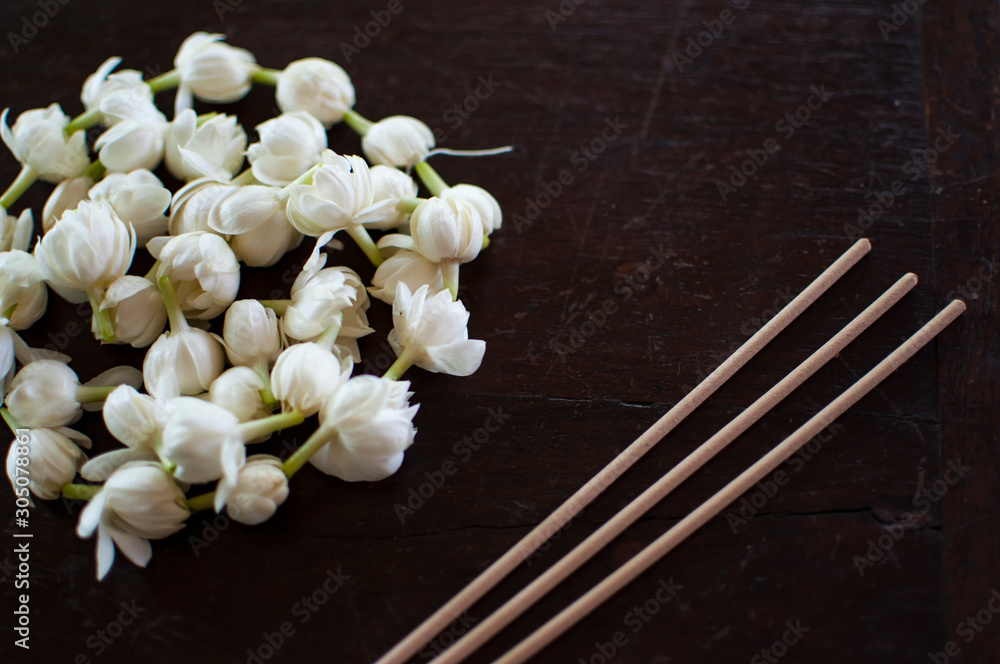 Fragrant jasmine blossom garland wrapped in circle on wooden table ...