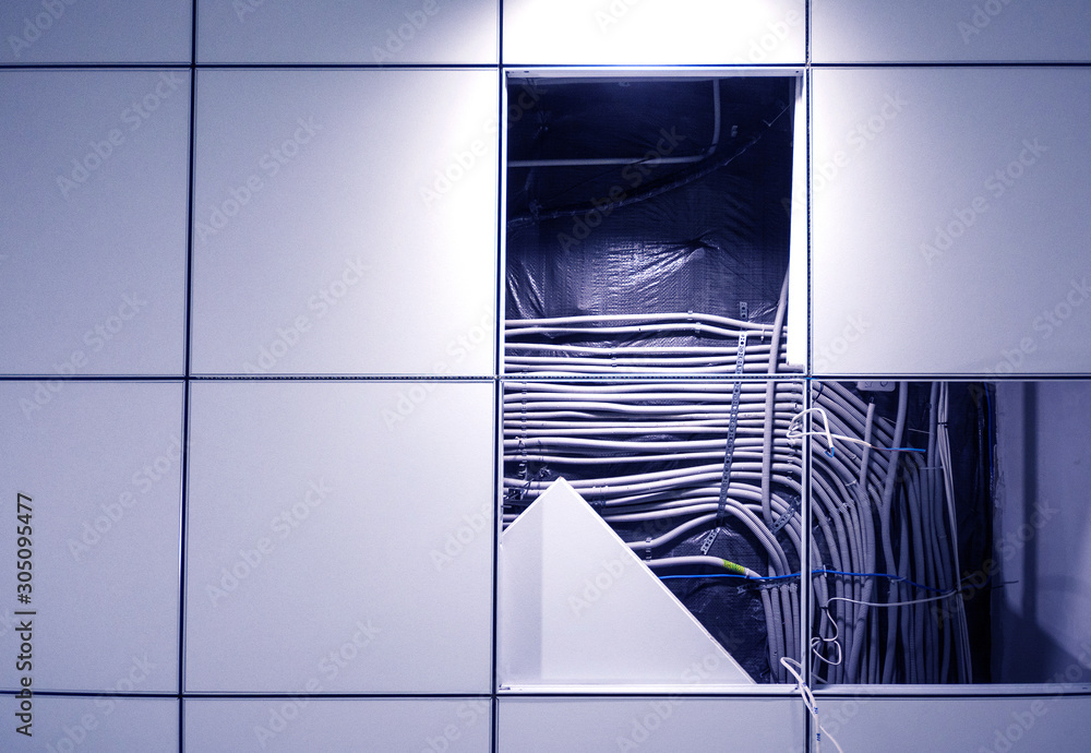 Corrugated electrical wires are located on the ceiling, hidden under ...