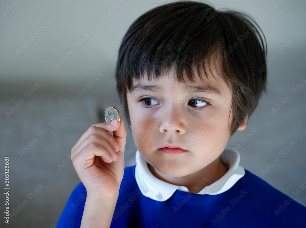 Cropped shot of School boy looking at one pound coin on his hand, Child ...