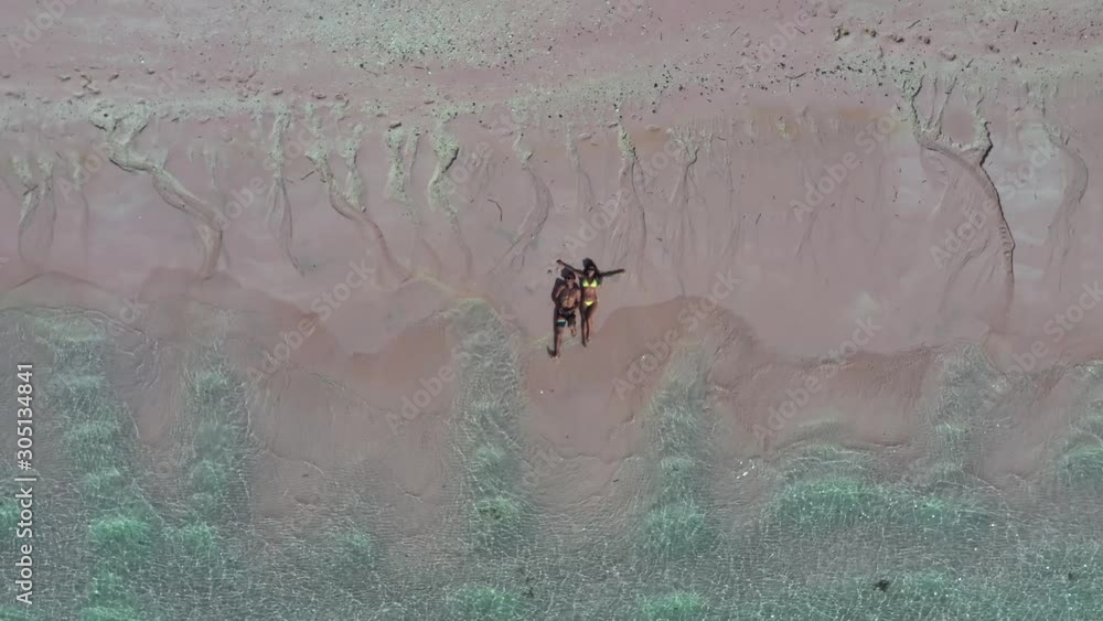 Couple laying on sandy beach on Komodo Island in Indonesia. This island ...