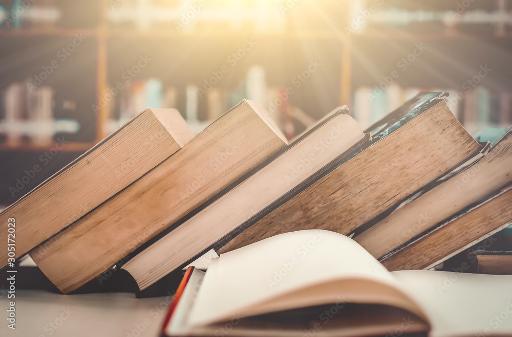 Stack of books in the library and blur bookshelf background Stock Photo ...