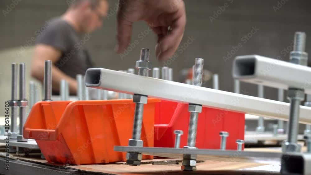 Employees assemble the structure made of steel profiles bolted with ...