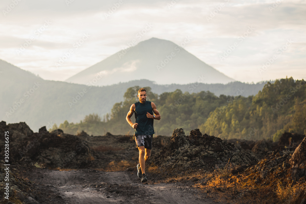 Young athlete man trail running in mountains in the morning. Amazing ...
