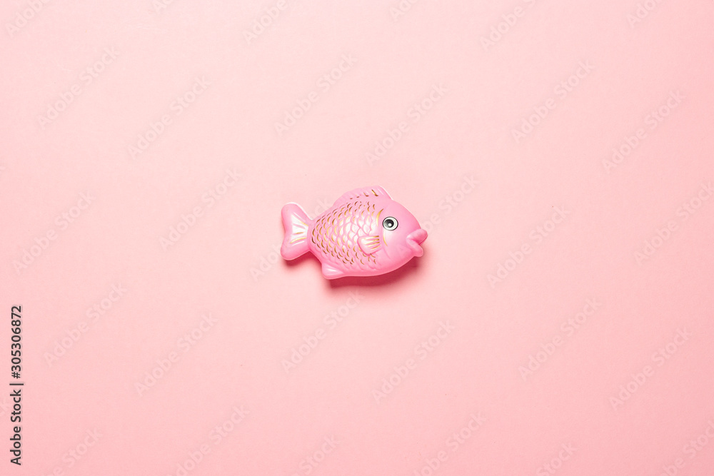 Plastic toy fish on a pink background. The concept of child development ...