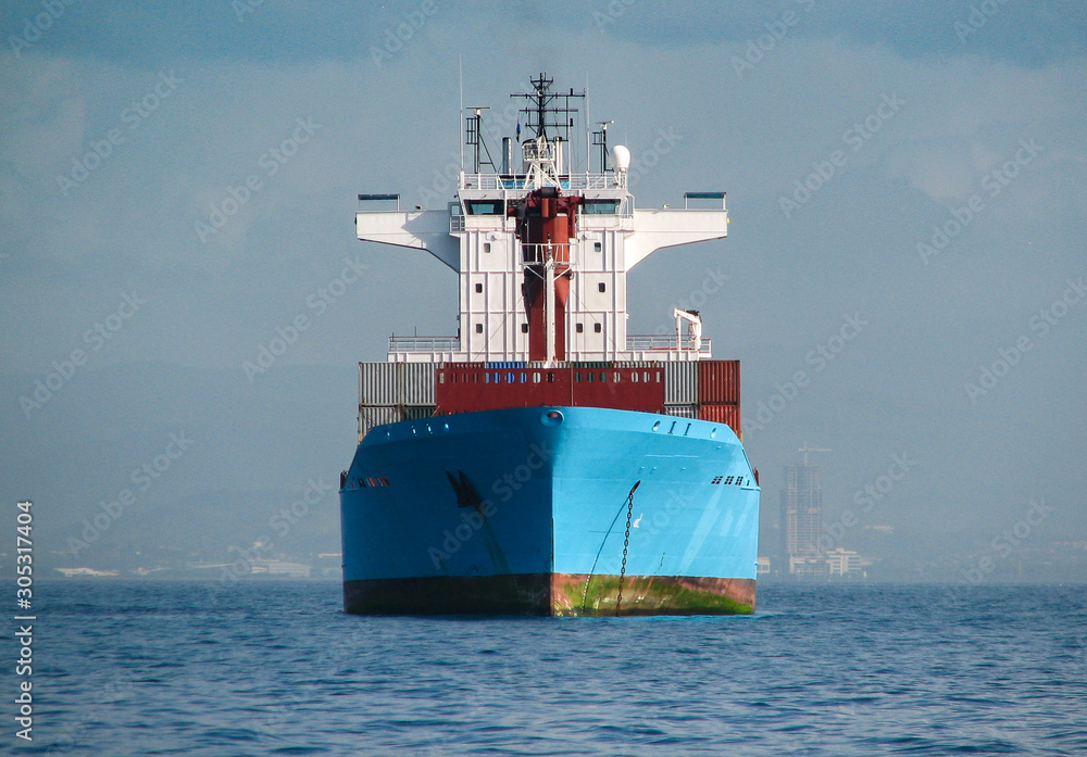 Red, white and blue container ship at anchor awaiting approval to ...