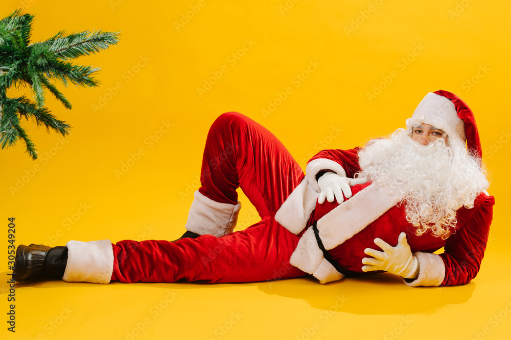 Santa Claus lying on the floor in impudent shameless manner, holding ...