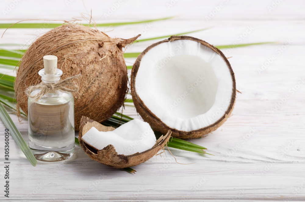 Coconut oil in glass jar and shell pieces on white wooden table Stock ...