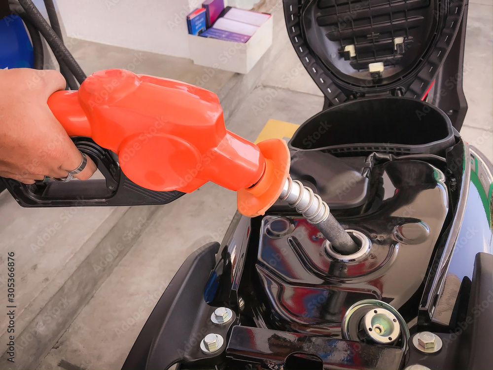 Closeup of the hand of the employee holding the fuel dispenser and ...