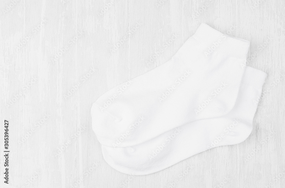 Pair blank white medium socks flat lay on white wood board, side view ...