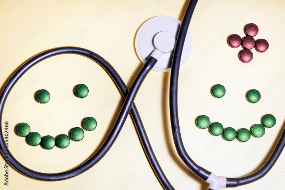 Smileys of a smiling doctor and patient, made of a statoscope and multi ...