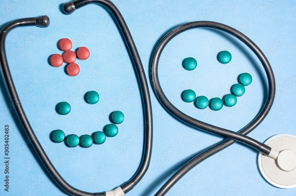 Smileys of a smiling doctor and patient, made of a statoscope and multi ...