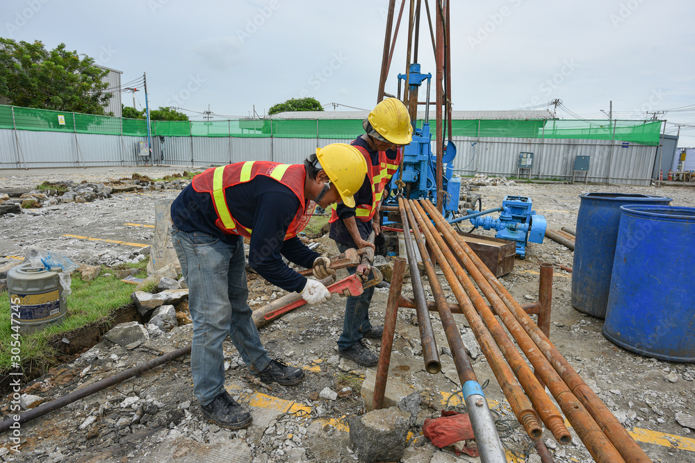 Construction workers drilling obtaining soil samples field for ...