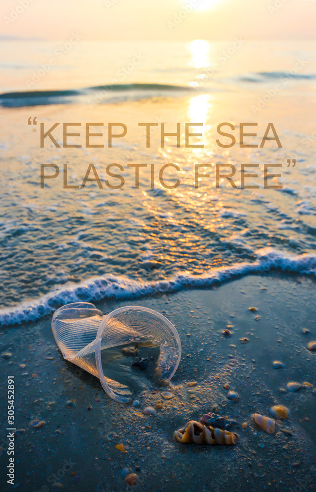 Plastic glass lies on the beach in sunset and pollutes the sea and ...