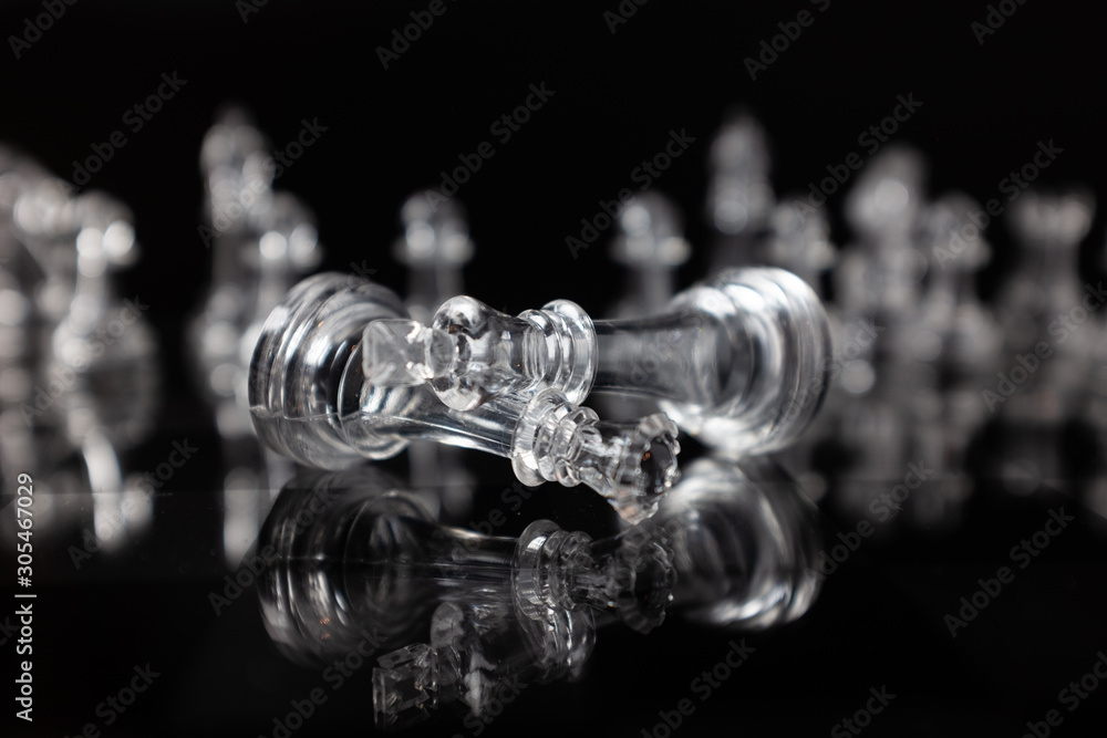 Fallen King and Queen Transparent methacrylate chess pieces on a black ...