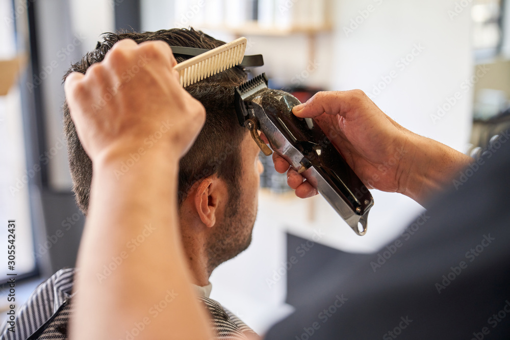 Stock photo of a detail of the hands of a barber cutting hair with a ...