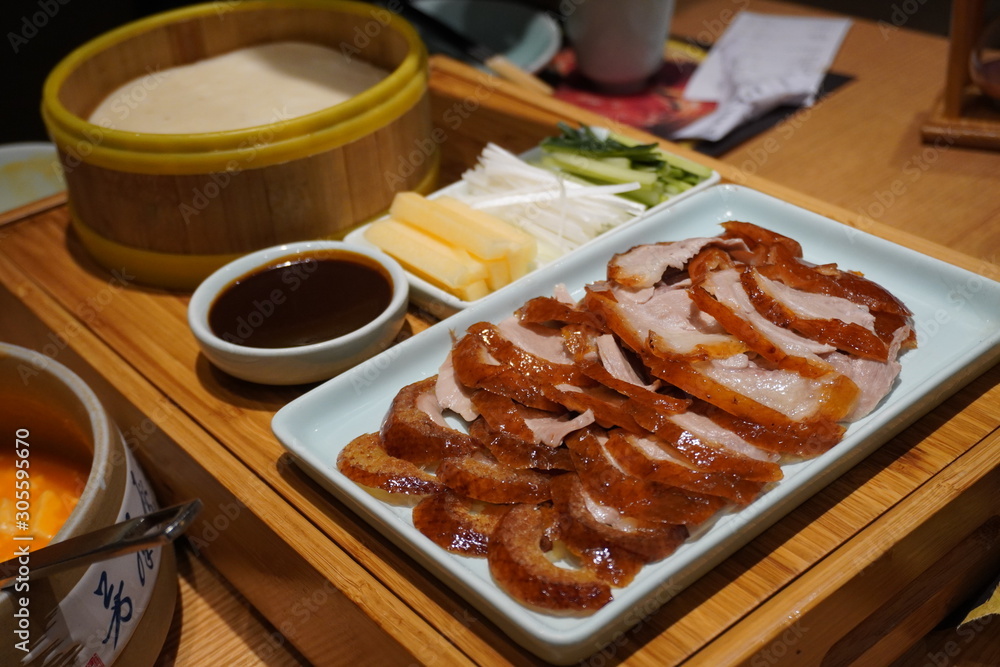 Thin crispy skin of Peking duck wrapped with leek, cucumber and melon ...