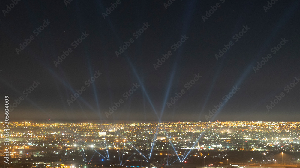 Spotlights in the Night Sky with Beams of Light in a Small City Stock ...