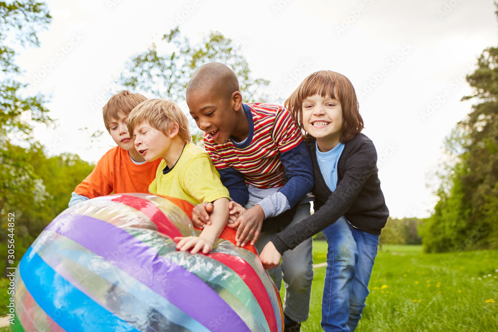 Lachende Kinder rollen einen bunten Ball Stock Photo | Adobe Stock