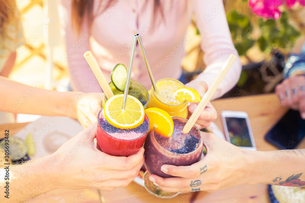Millennial Friends toasting and drinking different cocktails at the bar ...