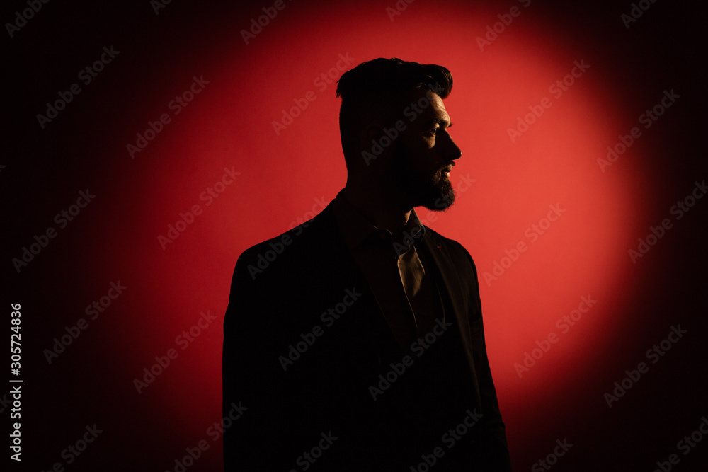 Dark male silhouette. Silhouette of man with beard over red background ...