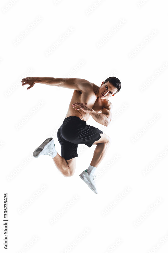 Muscle male model in black sports shorts and white sneakers in a ...