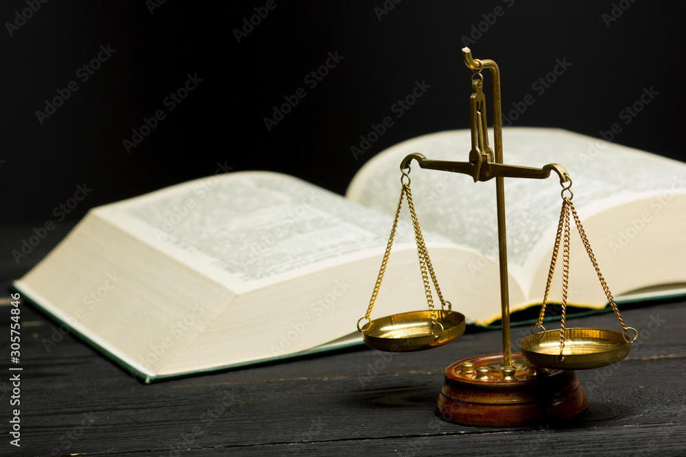 Law concept - Open law book with a wooden judges gavel on table in a ...