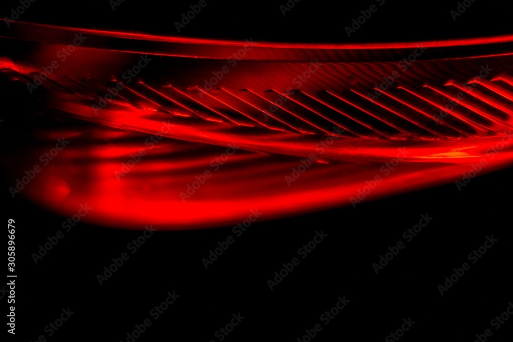 Abstract red and black background showing a detail of a rear red tail ...