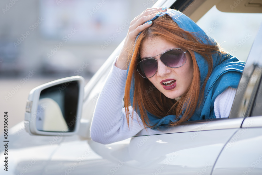 Young woman driving a car backwards. Girl with funny expression on her ...