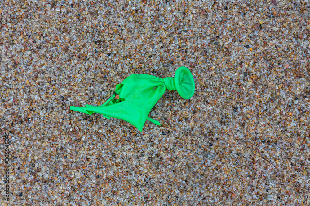 Environmental pollution - the rest of a green balloon, lying on the ...