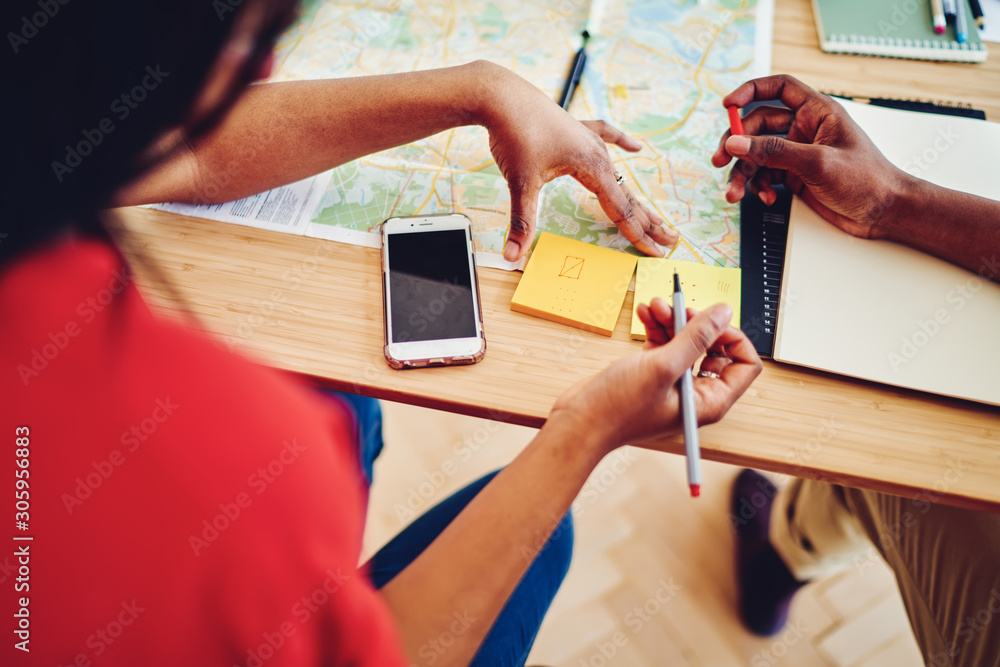 Cropped image of male and female colleagues making notes of place for ...