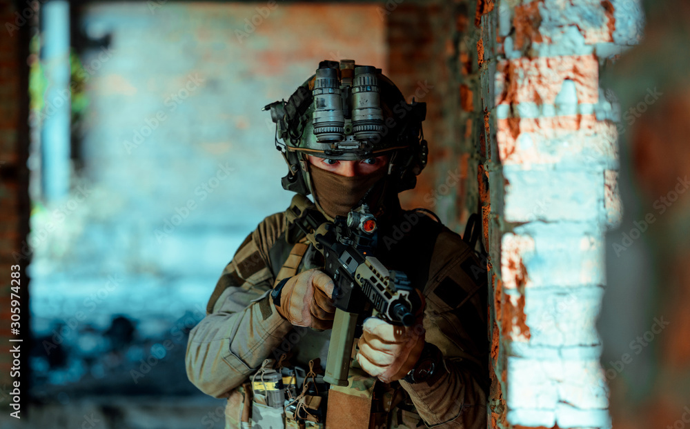 Man in uniform with machine gun and night-vision device stand beside ...